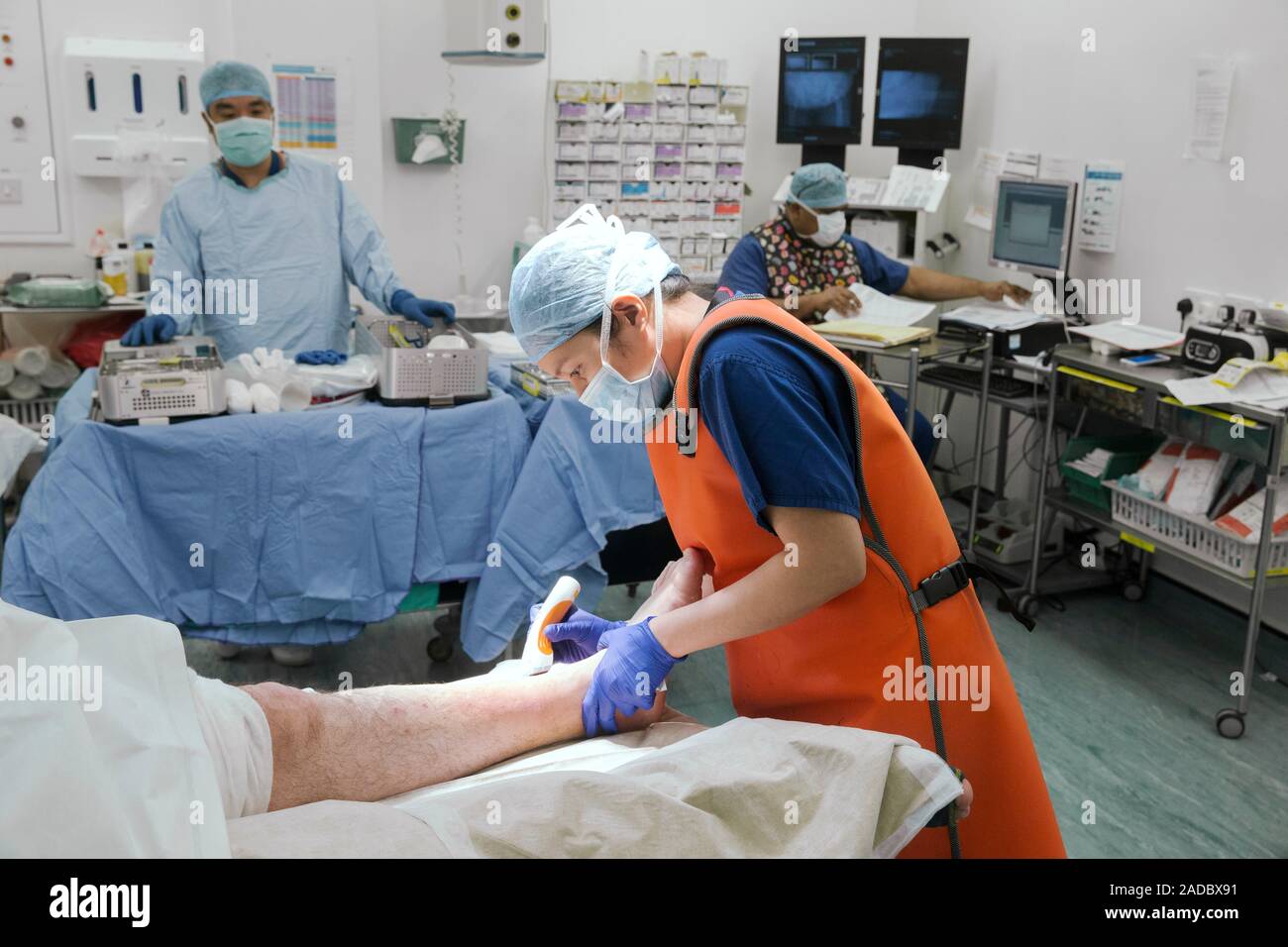 Preparing for surgery. Surgical nurses and technician preparing a ...
