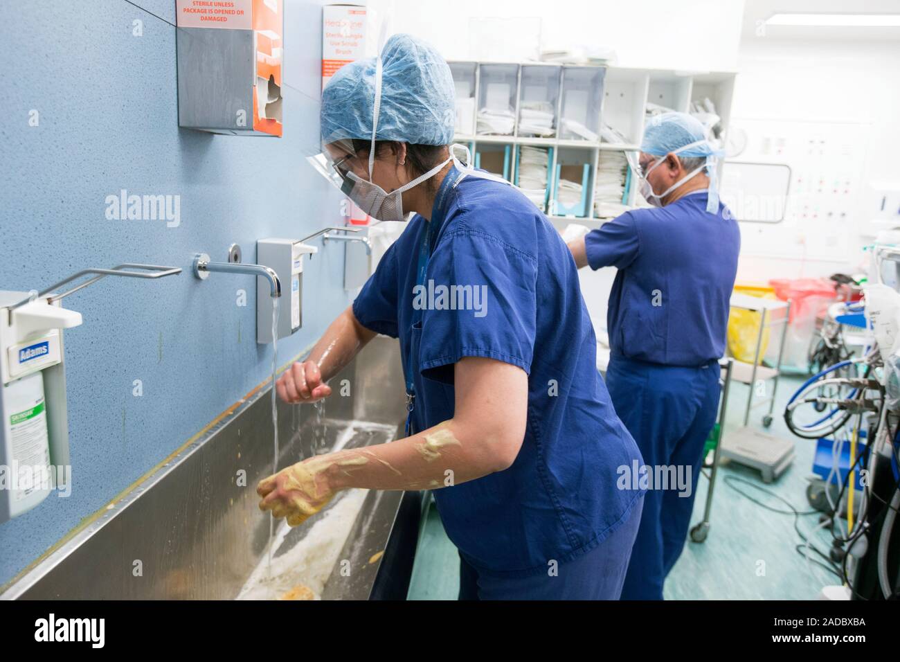 Surgical team 'scrubbing up'. Surgeon and nurse washing their hands and ...
