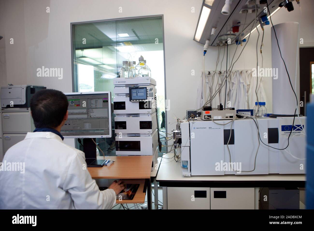 Proteomics and mass spectrometry analysis. Researcher using a mass spectrometer to analyse ...