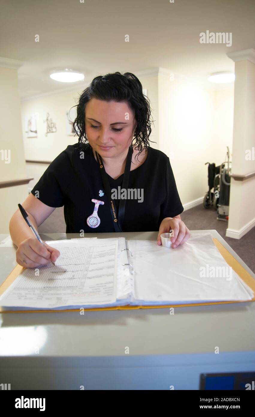 Care home drug dispensing. Care home nurse checking the medication ...