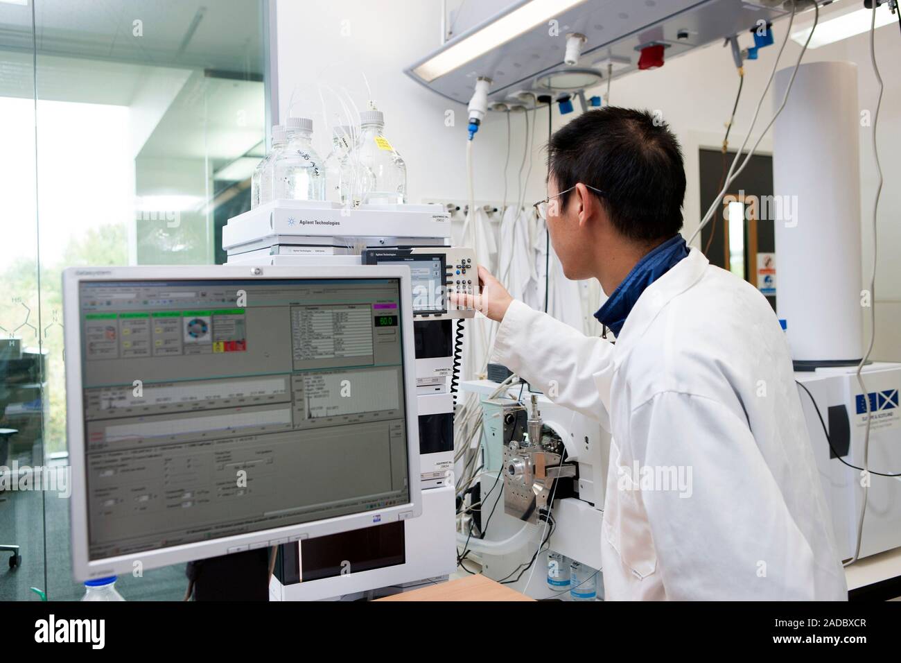 Proteomics and mass spectrometry analysis. Researcher using a mass spectrometer to analyse ...