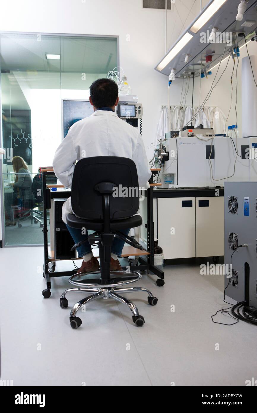 Proteomics and mass spectrometry analysis. Researcher using a mass spectrometer to analyse ...