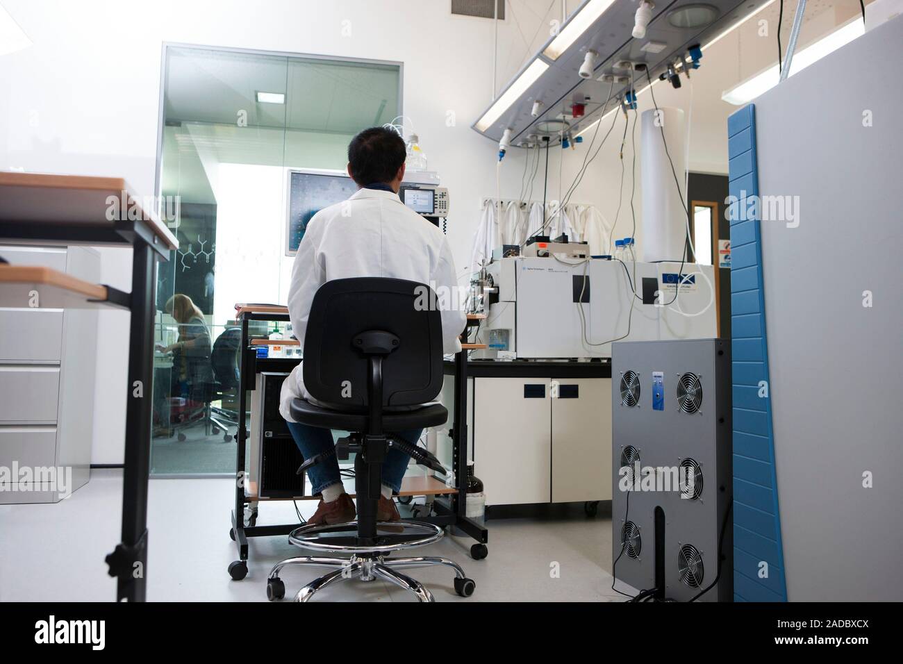 Proteomics and mass spectrometry analysis. Researcher using a mass spectrometer to analyse ...