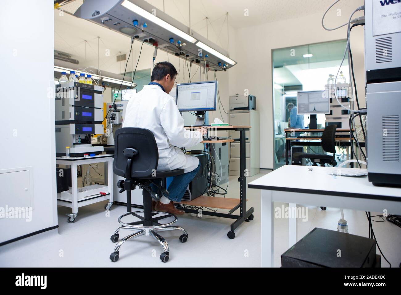 Proteomics and mass spectrometry analysis. Researcher using a mass spectrometer to analyse ...