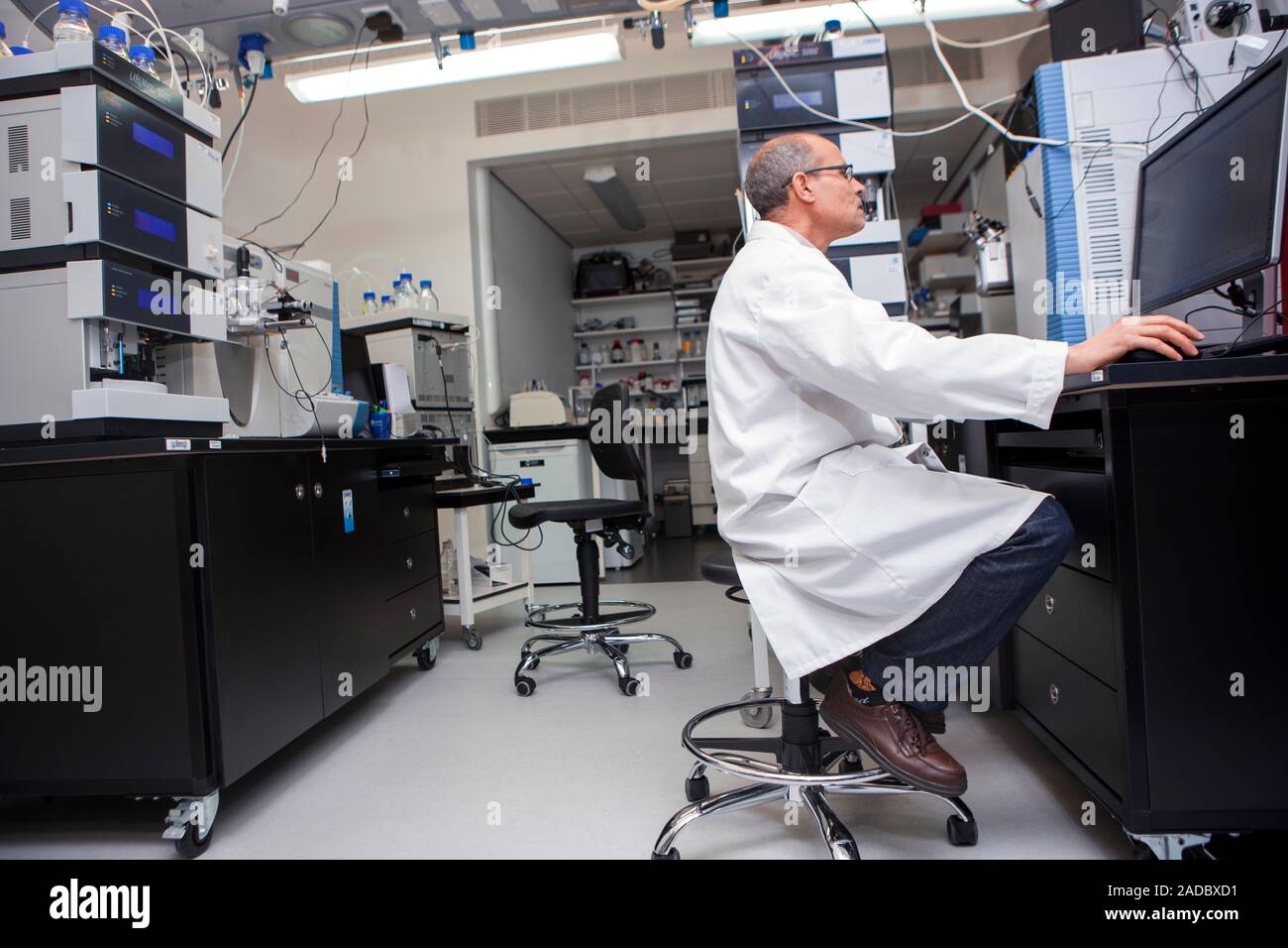 Proteomics and mass spectrometry analysis. Researcher using a mass spectrometer to analyse ...