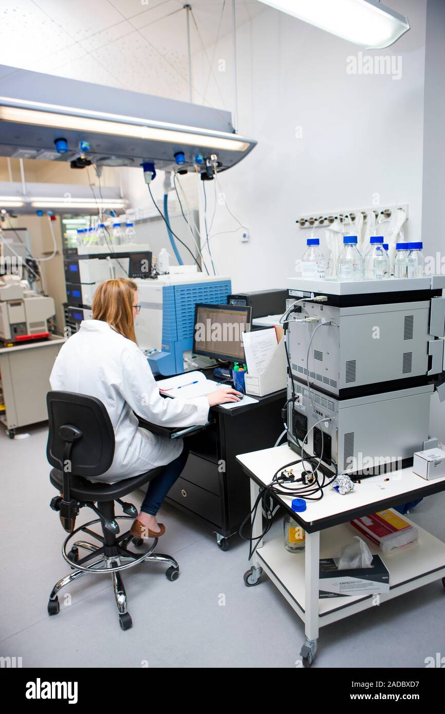 Proteomics and mass spectrometry analysis. Researcher using a mass spectrometer to analyse ...