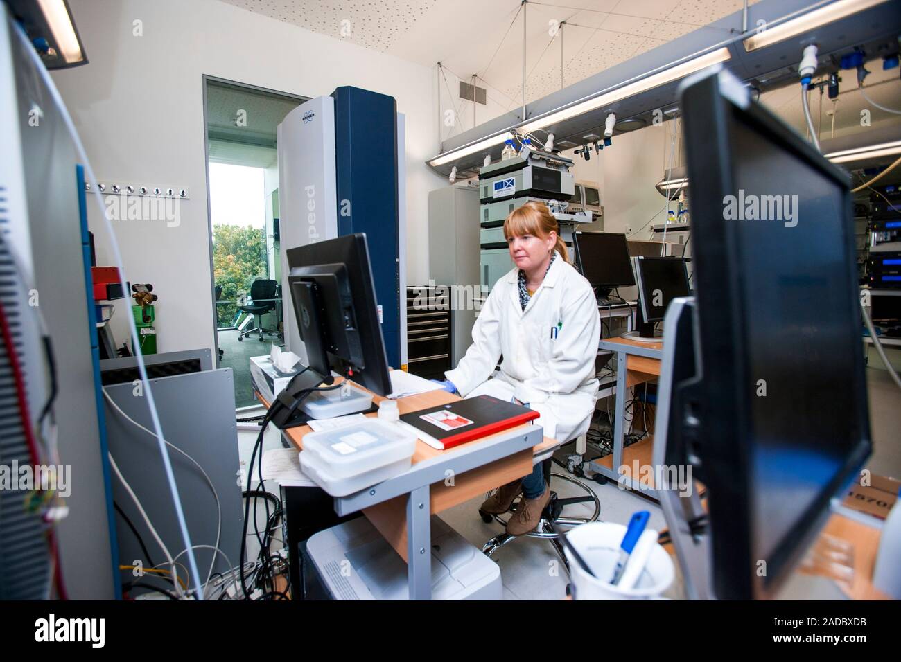 Proteomics and mass spectrometry analysis. Researcher using a mass spectrometer to analyse ...