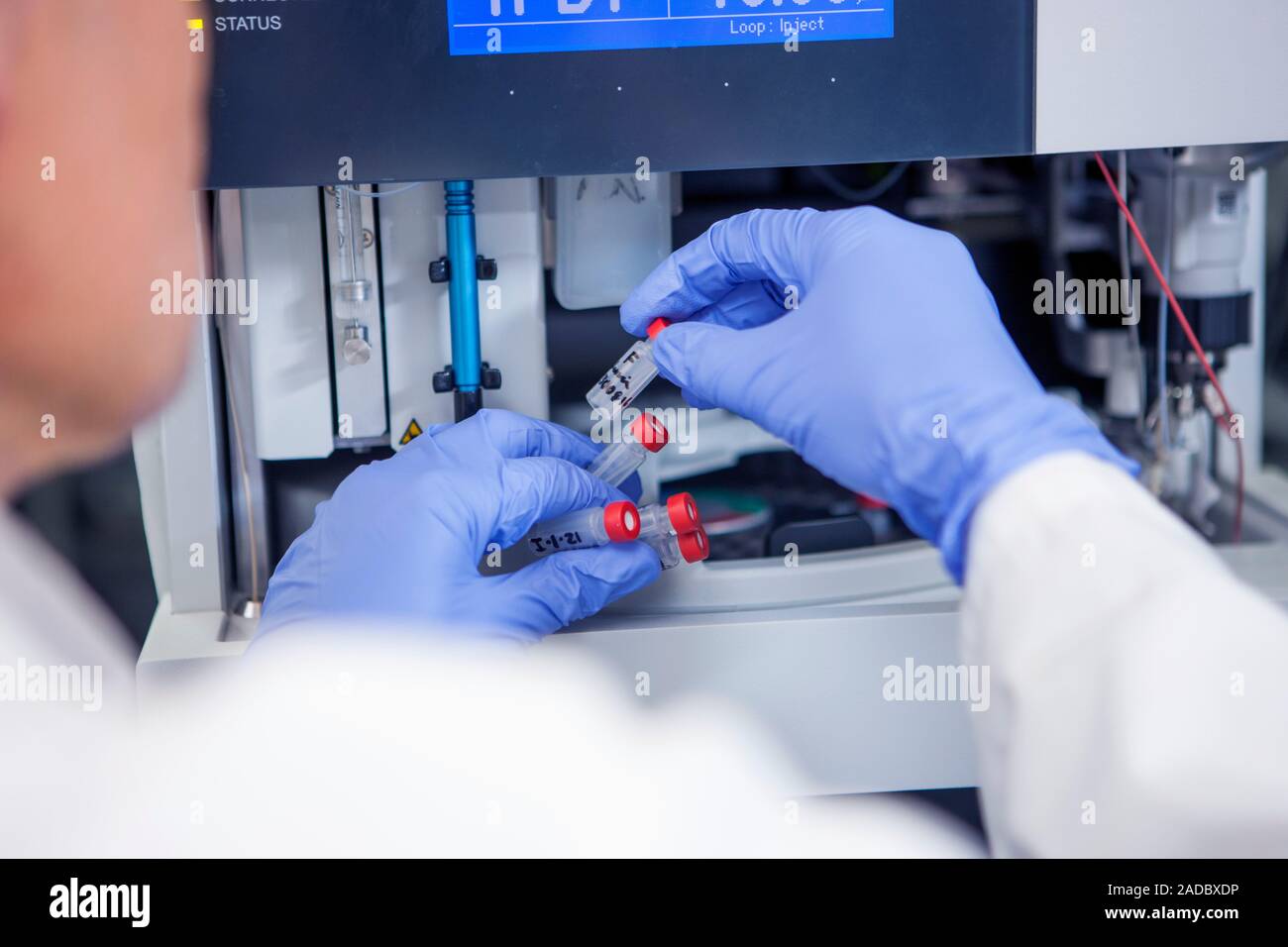 Mass spectrometry and protein analysis. Close-up of a researcher loading samples into mass ...