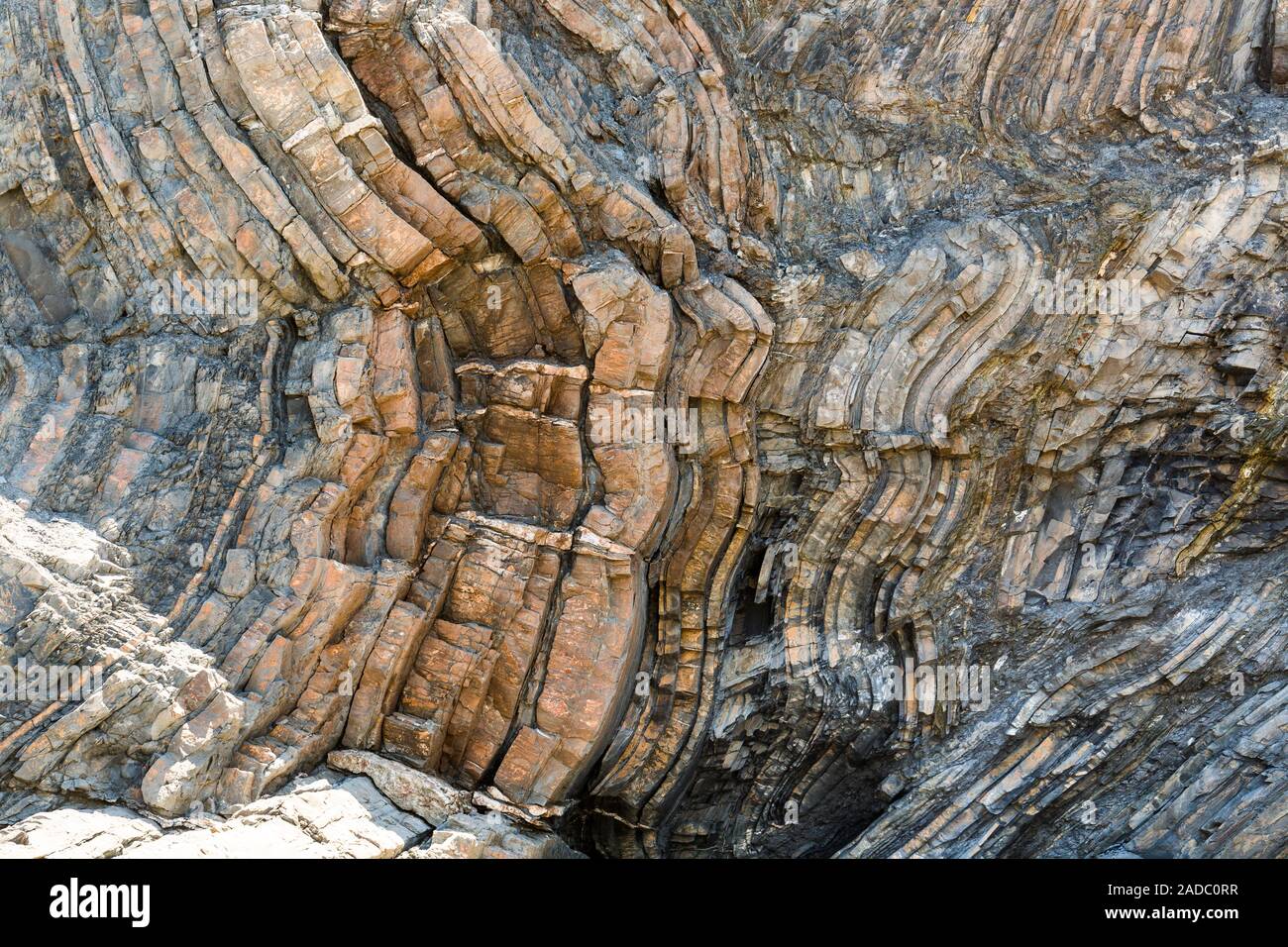 Folded and fractured sedimentary rocks on a cliff facing the Atlantic ...