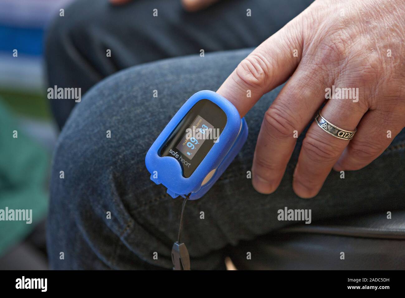 Pulse oximeter. Close-up of a pulse oximeter on the finger of a man ...