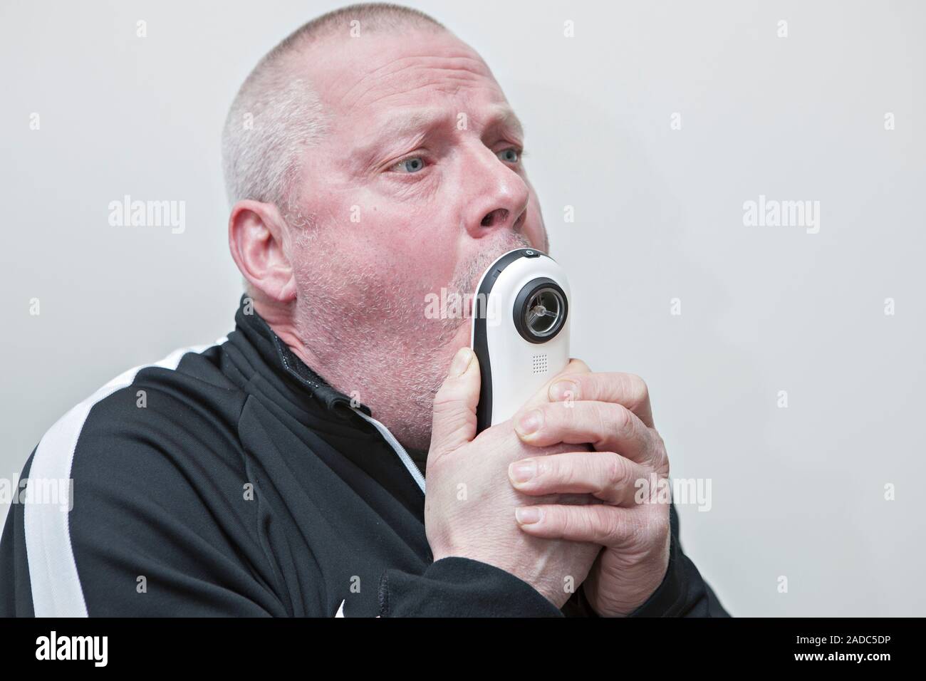 Lung Function Testing Patient Exhaling Hard Into A Small Handheld