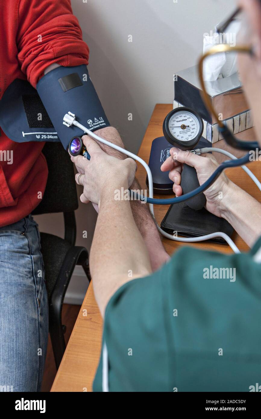 Blood pressure measurement. Paramedic at a general practice (GP) clinic ...