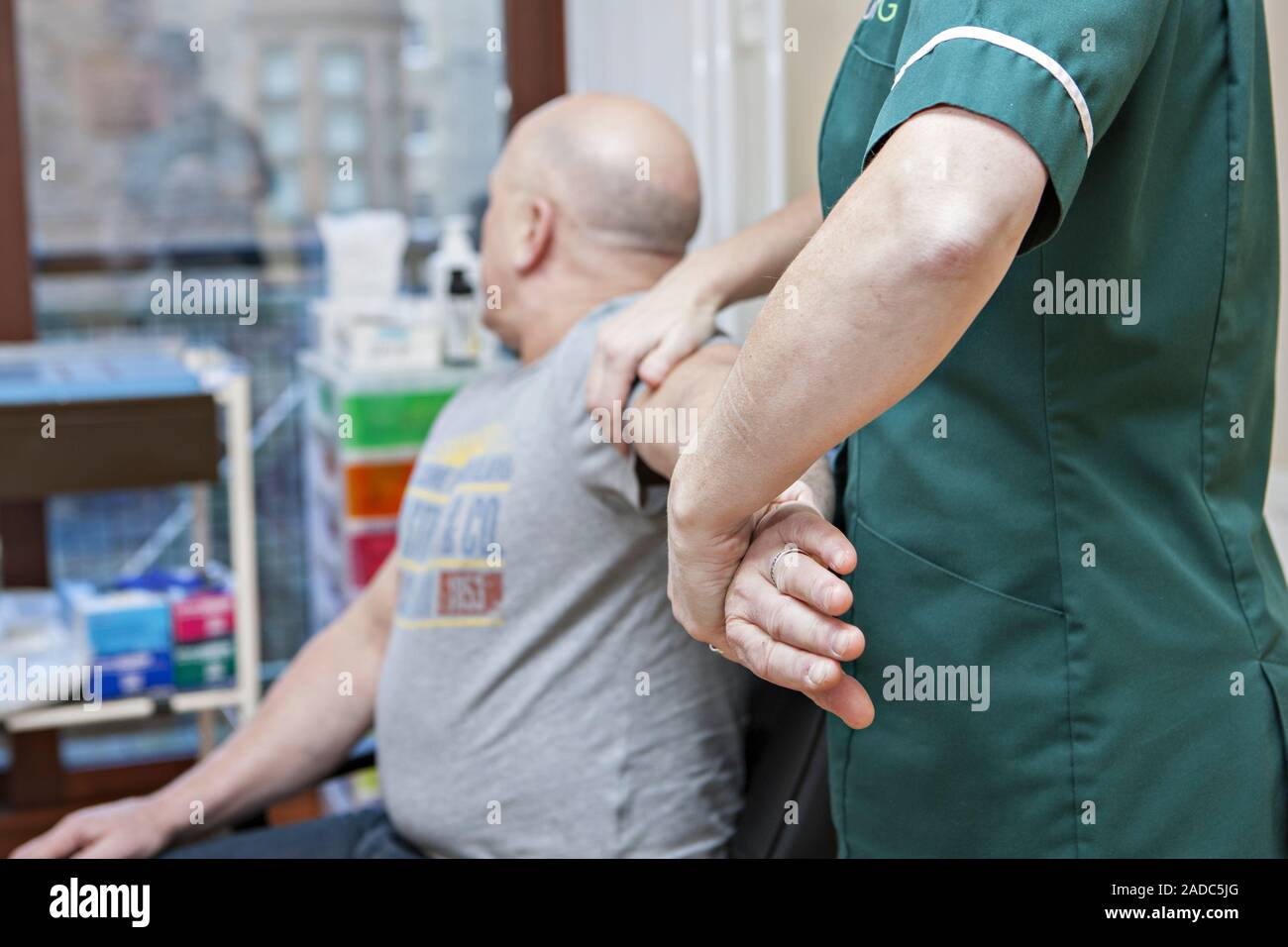 Carpal tunnel syndrome assessment. Paramedic assessing the shoulder ...