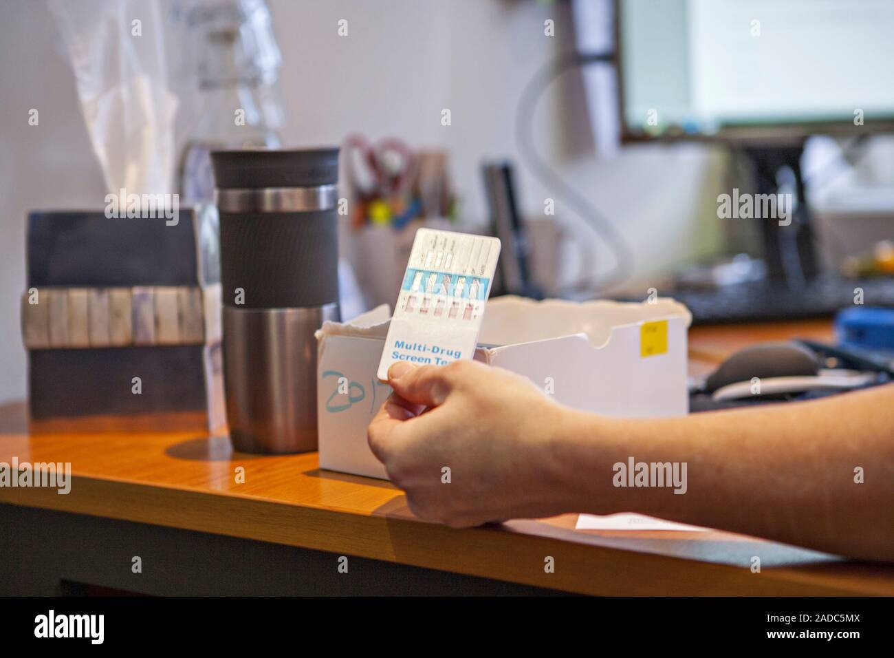 Urine multi-drug test kit. Medical practitioner holding a 5-panel urine ...