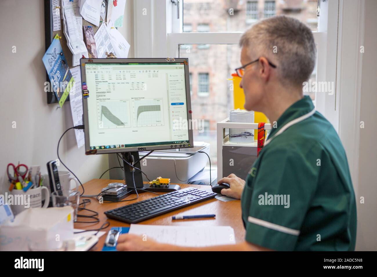 Lung function testing results. Paramedic assessing the results of a ...