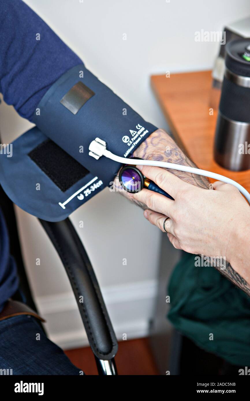Blood pressure measurement. Sphygmomanometer being used by a medical ...