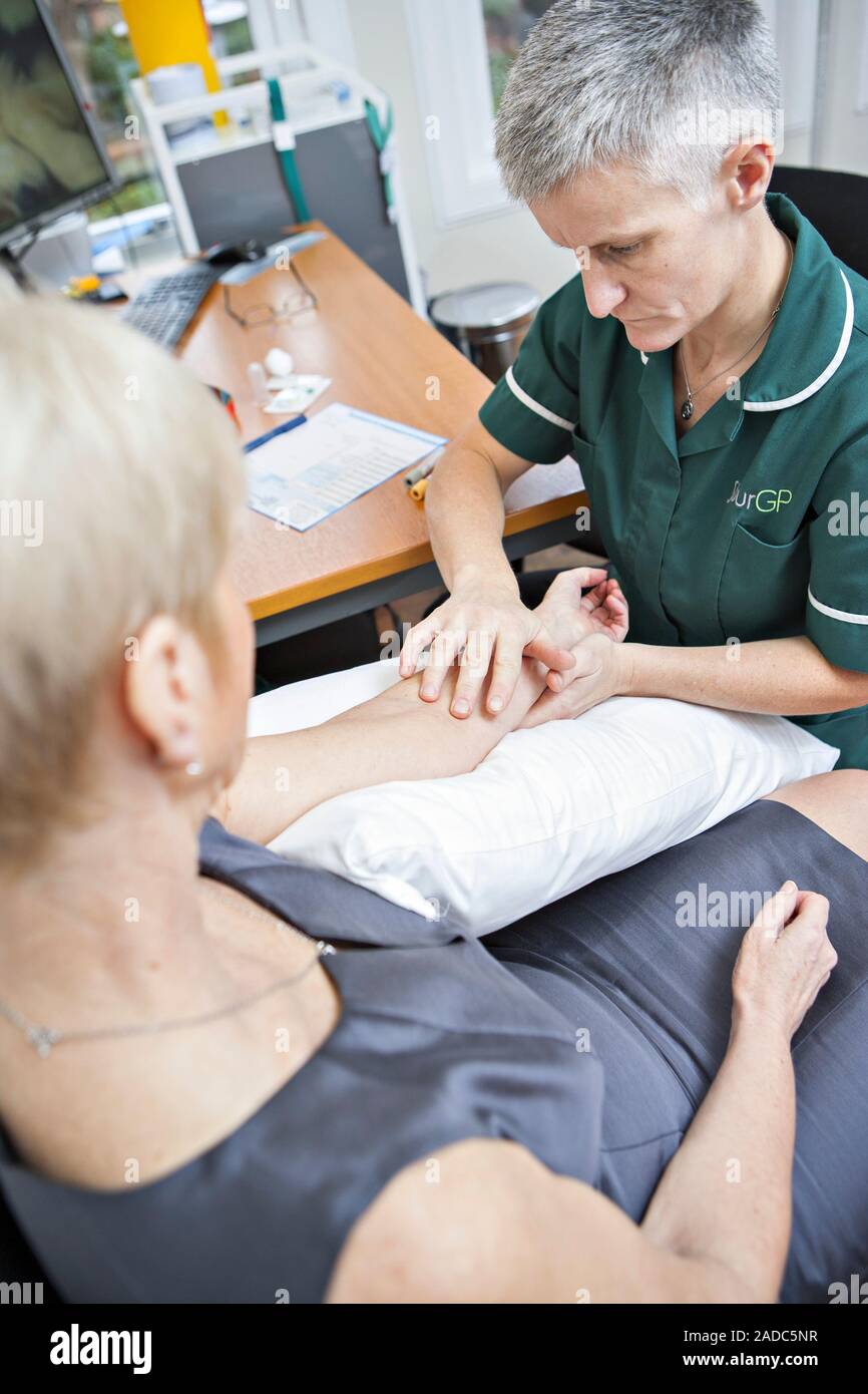 Blood sampling. Paramedic at a general practice (GP) clinic preparing ...