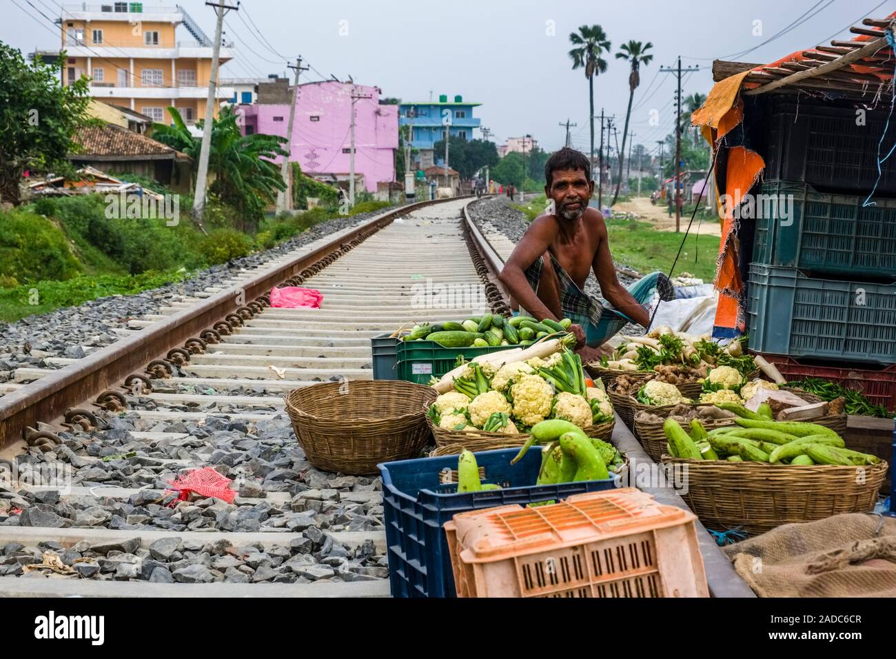 Vegetable market held on railway tracks, a man is selling cauliflowers ...
