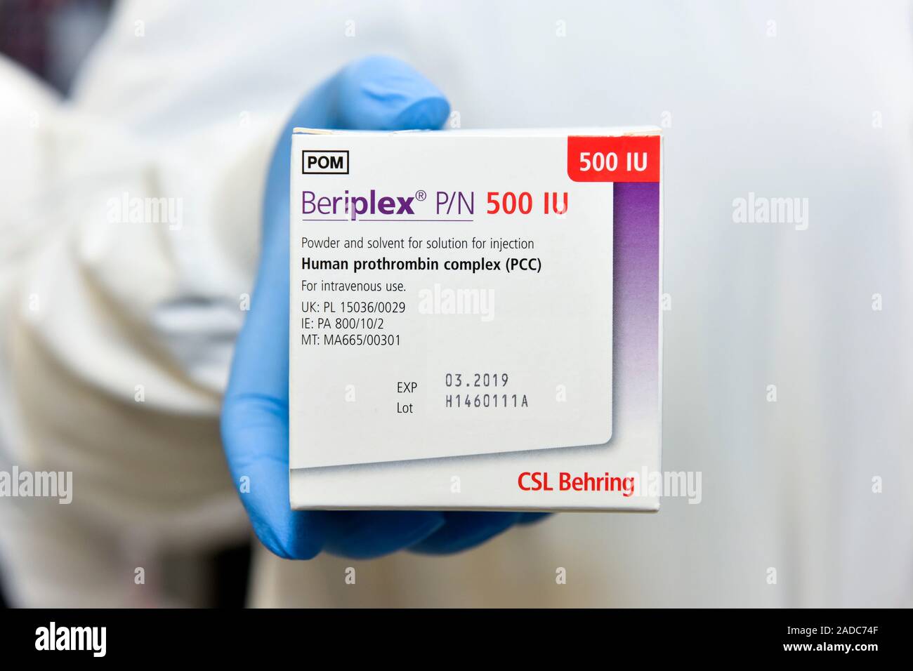 Prothrombin complex concentrate. Gloved hand holding the packaging for ...