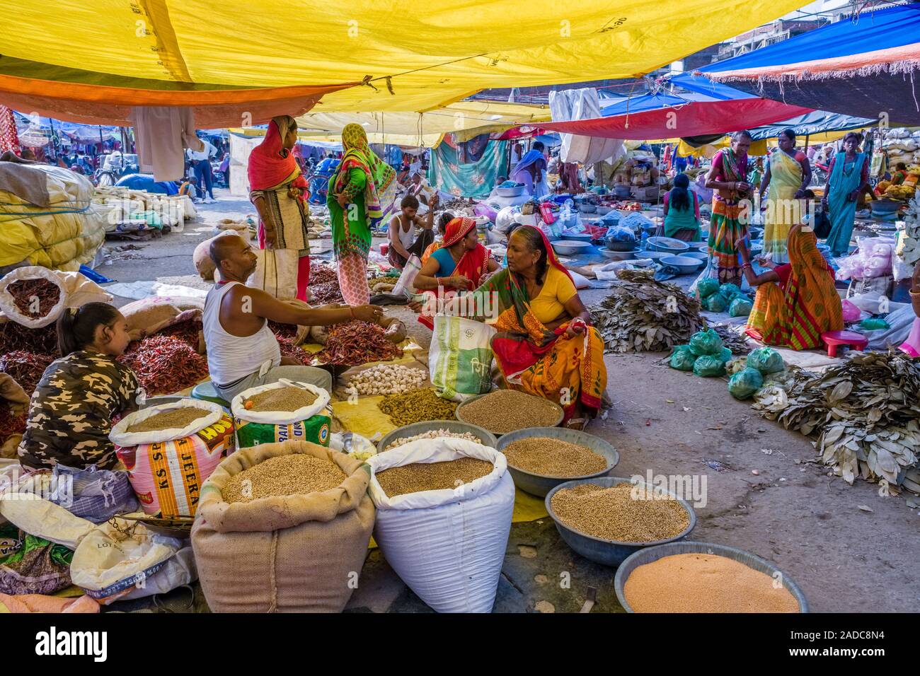 Different grains are sold at the weekly market, vendor and customer are ...
