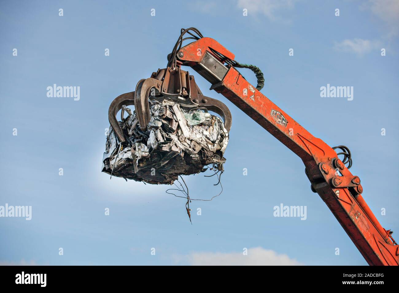 Scrapyard. Crushed cars being loaded onto a transporter at a scrapyard ...