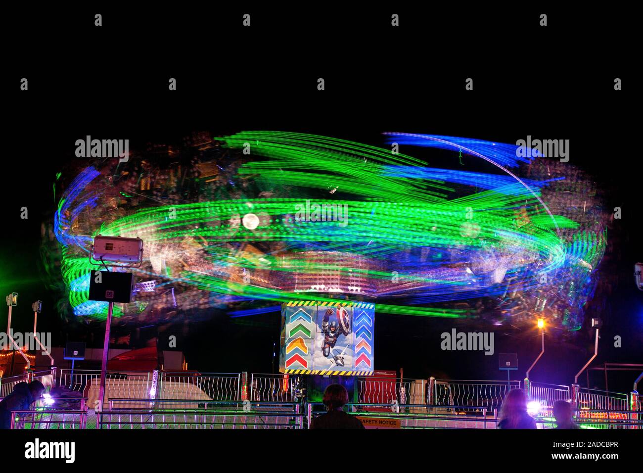 Long-exposure image of a funfair ride lit up at night. Photographed at ...