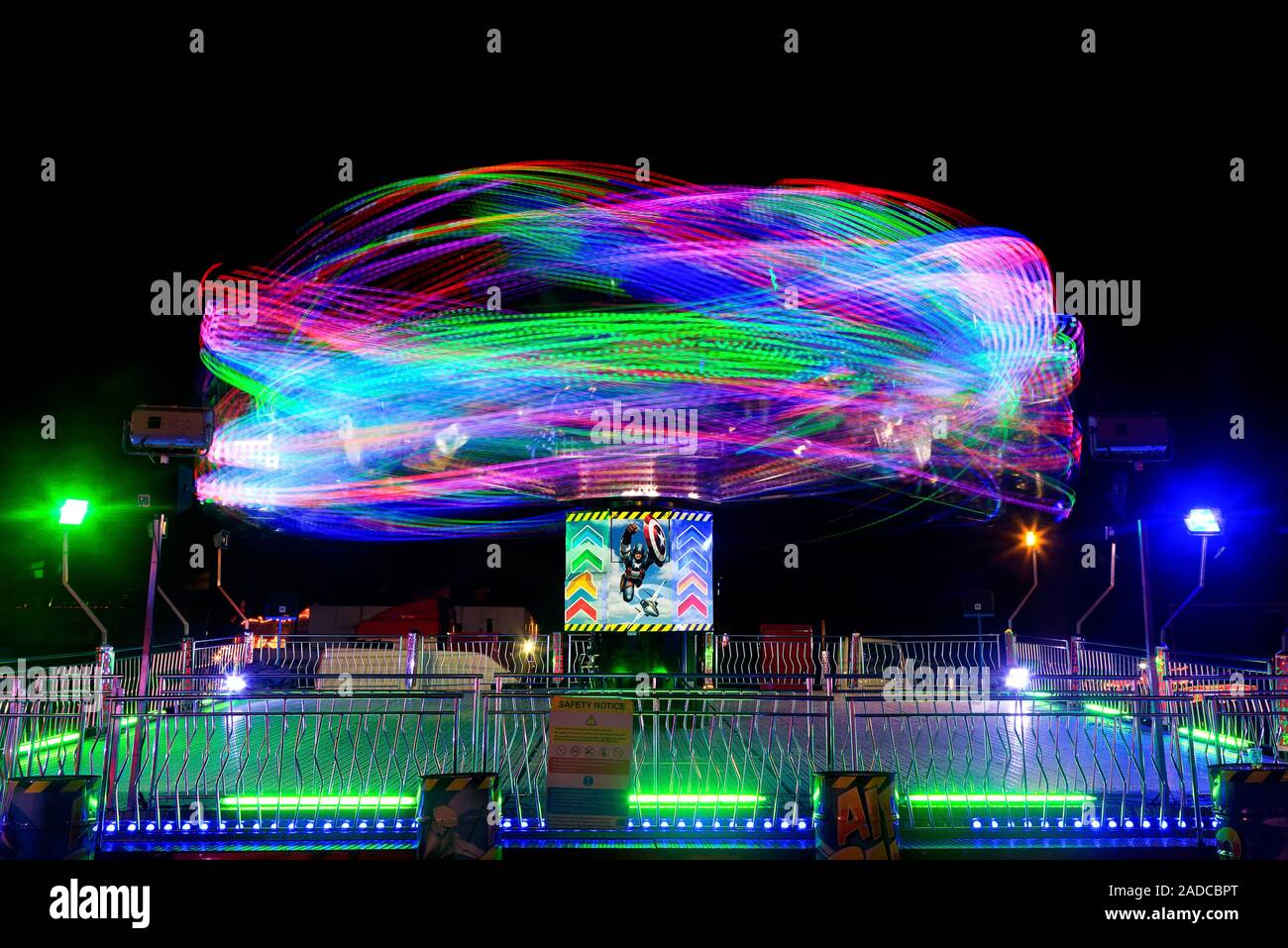Long-exposure image of a funfair ride lit up at night. Photographed at ...