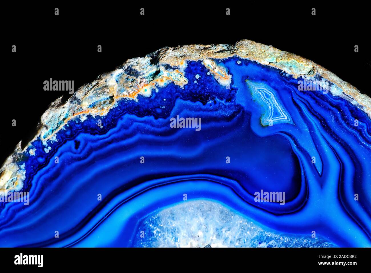 Close-up of a cross section of agate geode lit by LED lighting to show ...