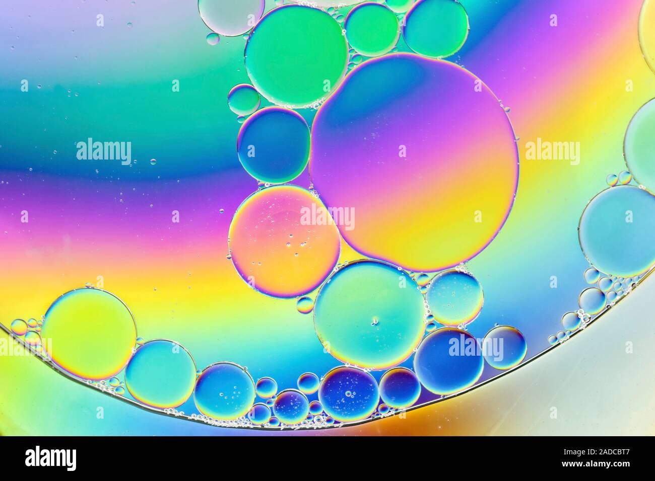 Macro photograph of oil resting on top of water. Oil and water do not ...