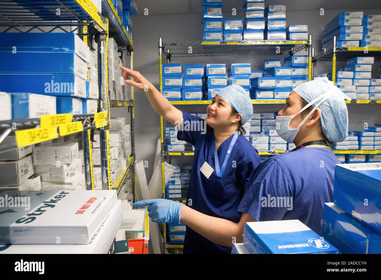 Hospital surgical staff members in a store cupboard, retrieving ...