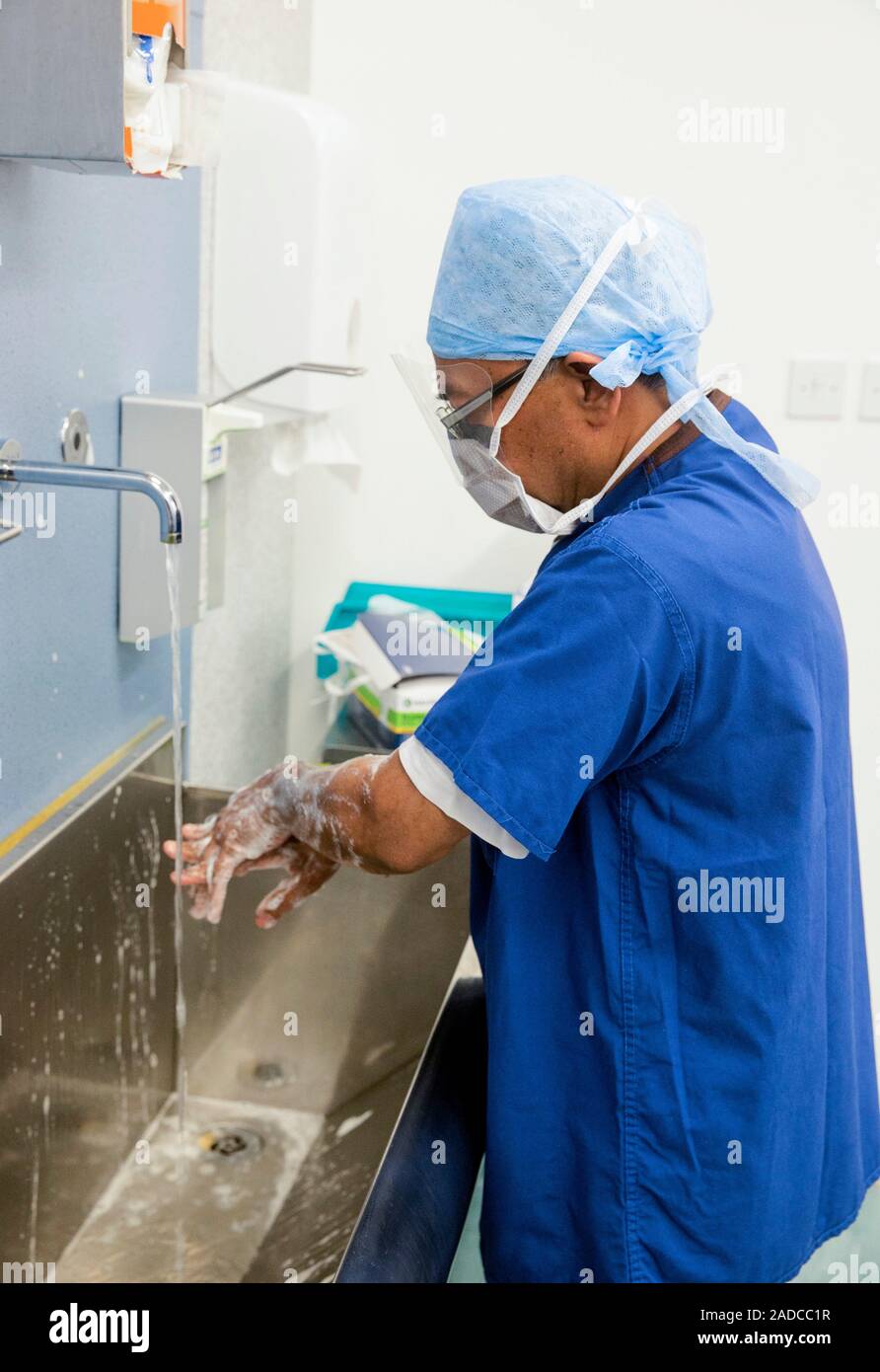 Surgeon washing hands in a hospital prior to carrying out an operation ...