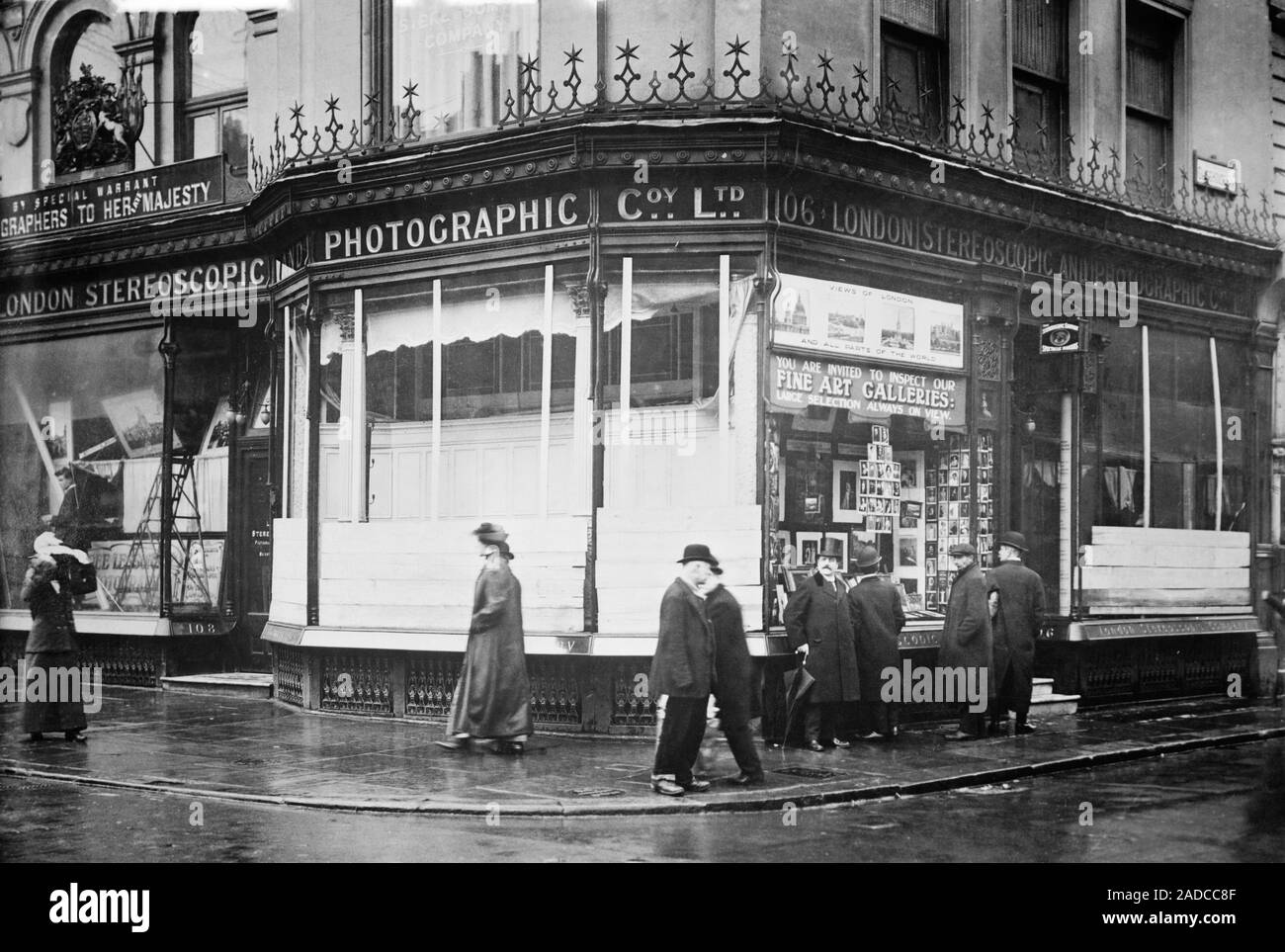 Damage caused by suffragettes. Shop window boarded up (centre) after ...