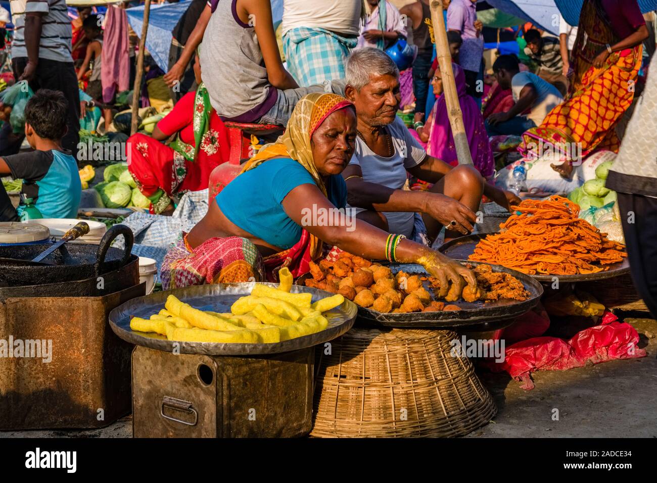 A man and a woman are offering snacks at the weekly vegetable market ...