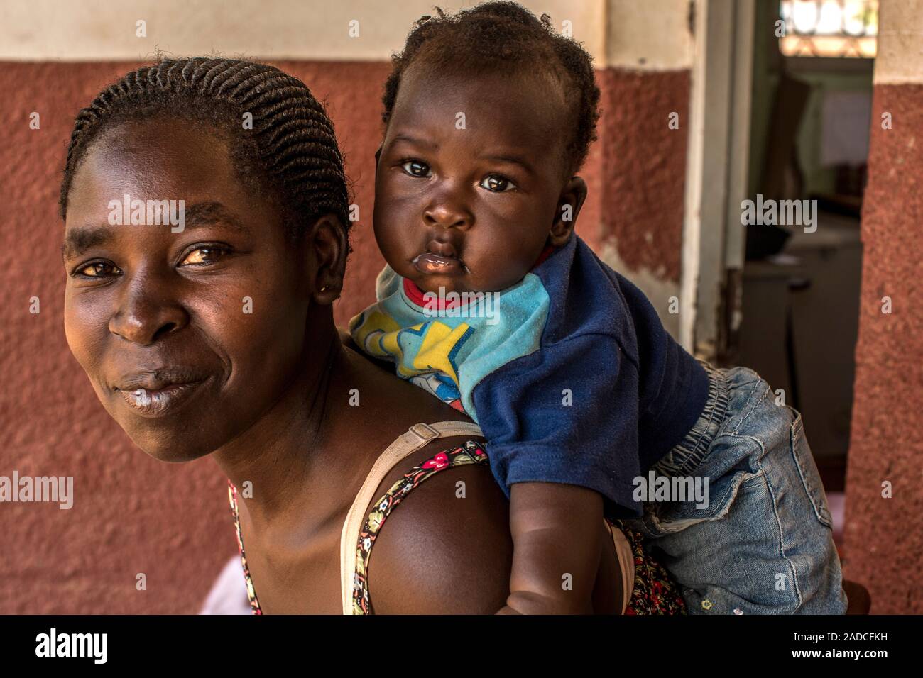 Baby carried on mother's back. Mother carrying her baby on her back ...