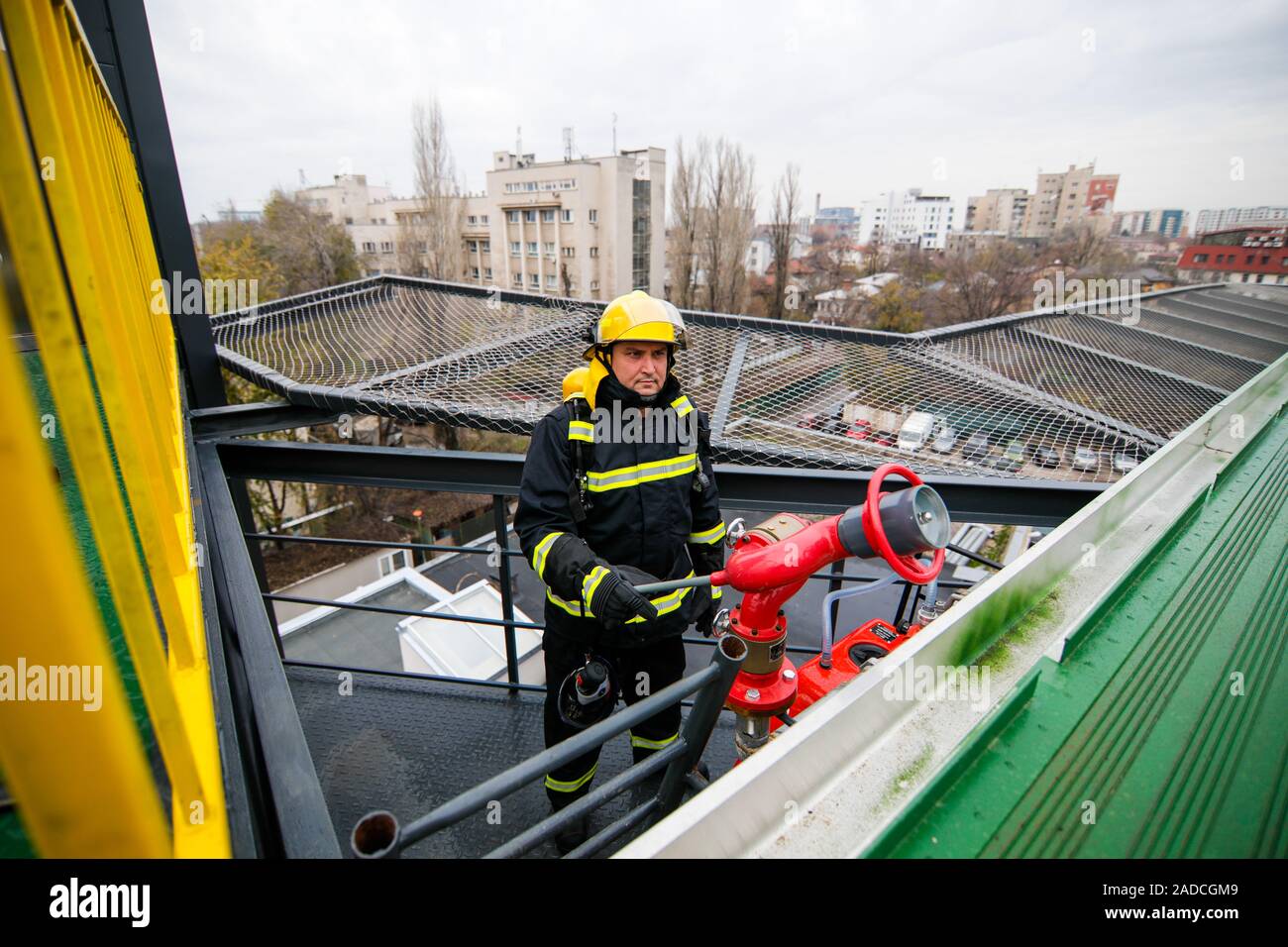 Bucharest, Romania - December 03, 2019: Firefighter holds a fire suppression system (hydrant) on ...