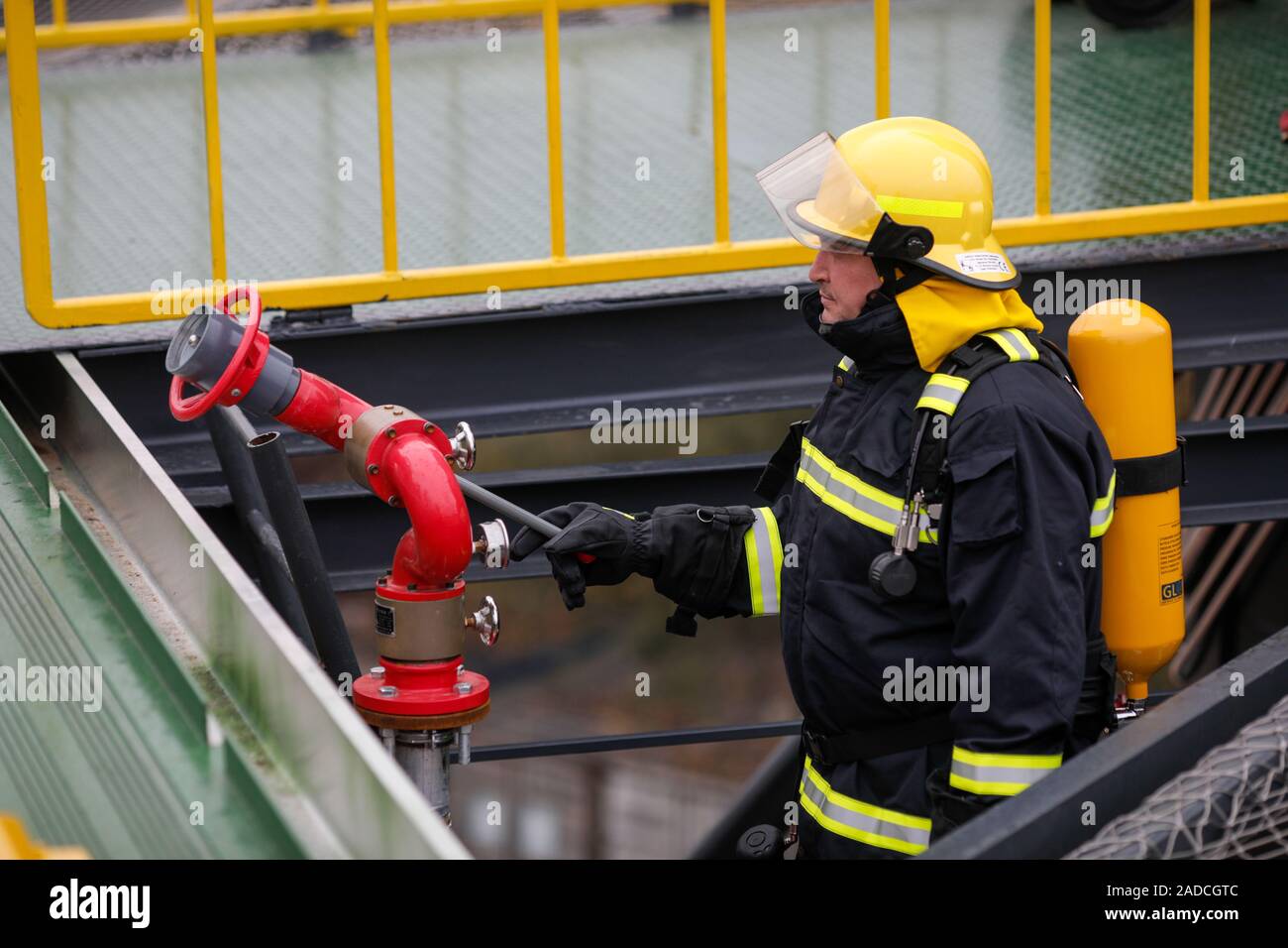 Bucharest, Romania - December 03, 2019: Firefighter holds a fire suppression system (hydrant) on ...