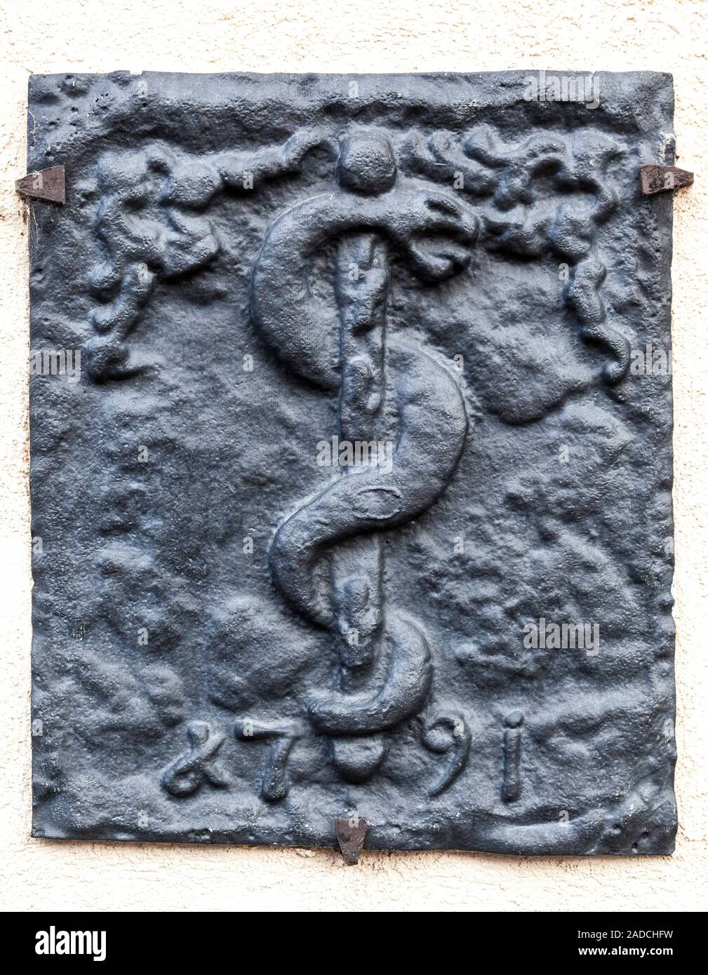 A metal plate in Bergheim, Alsace. The symbol of a serpent wound round ...