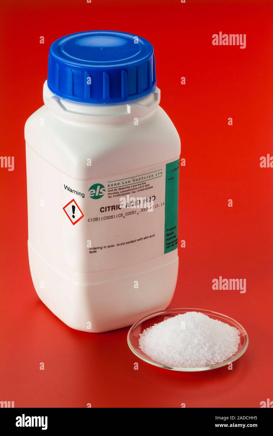 A plastic bottle containing citric acid and a watch glass of citric ...