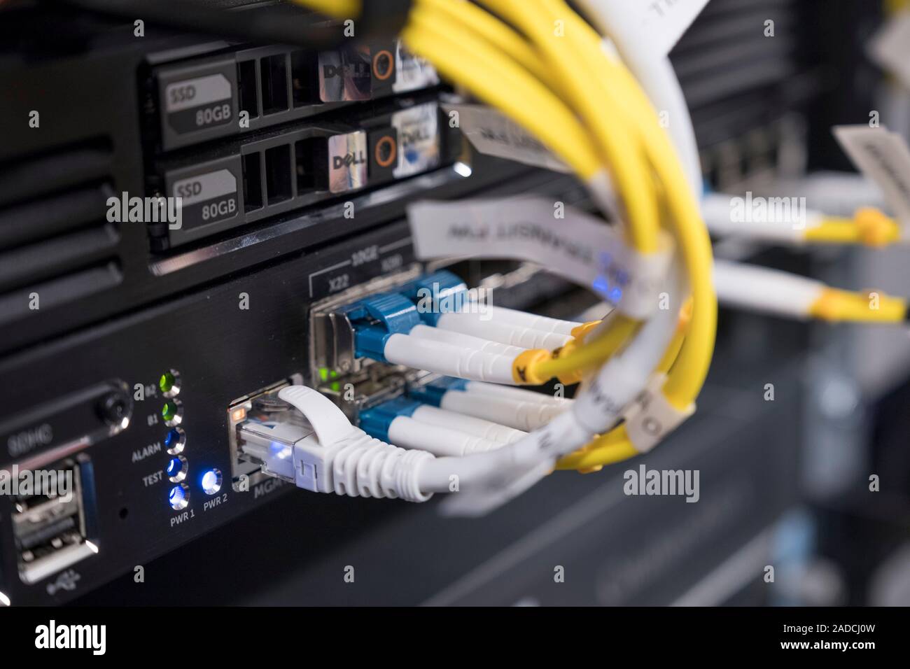 Close-up of cables plugged into the back of servers in a data centre ...