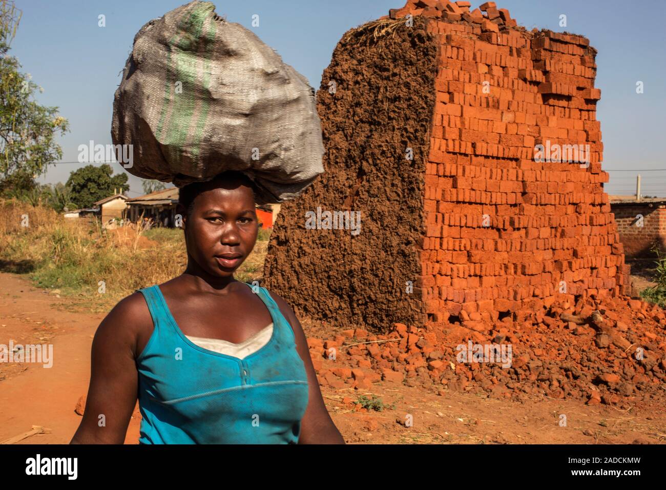 Head carrying in Uganda. Woman carrying a load on her head, while ...