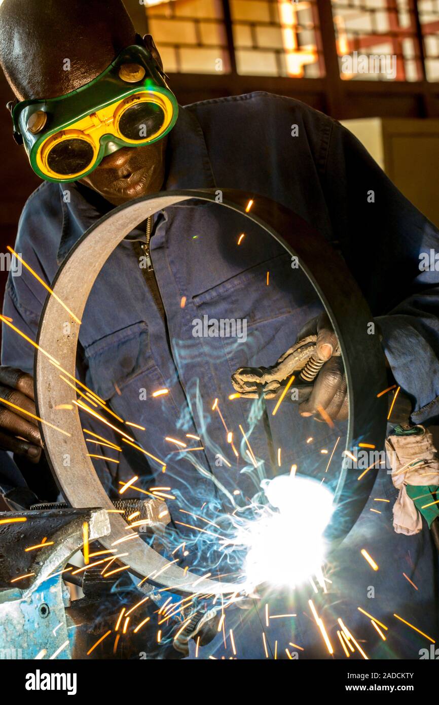 Metalworking using a welding tool. Photographed in Lacor, Gulu, Uganda ...