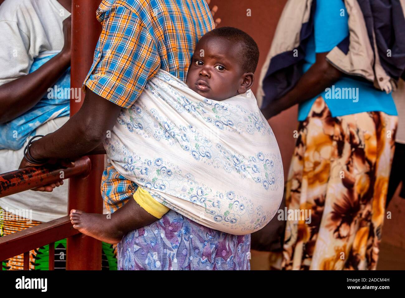 Baby carried on mother's back. Mother carrying her baby on her back ...