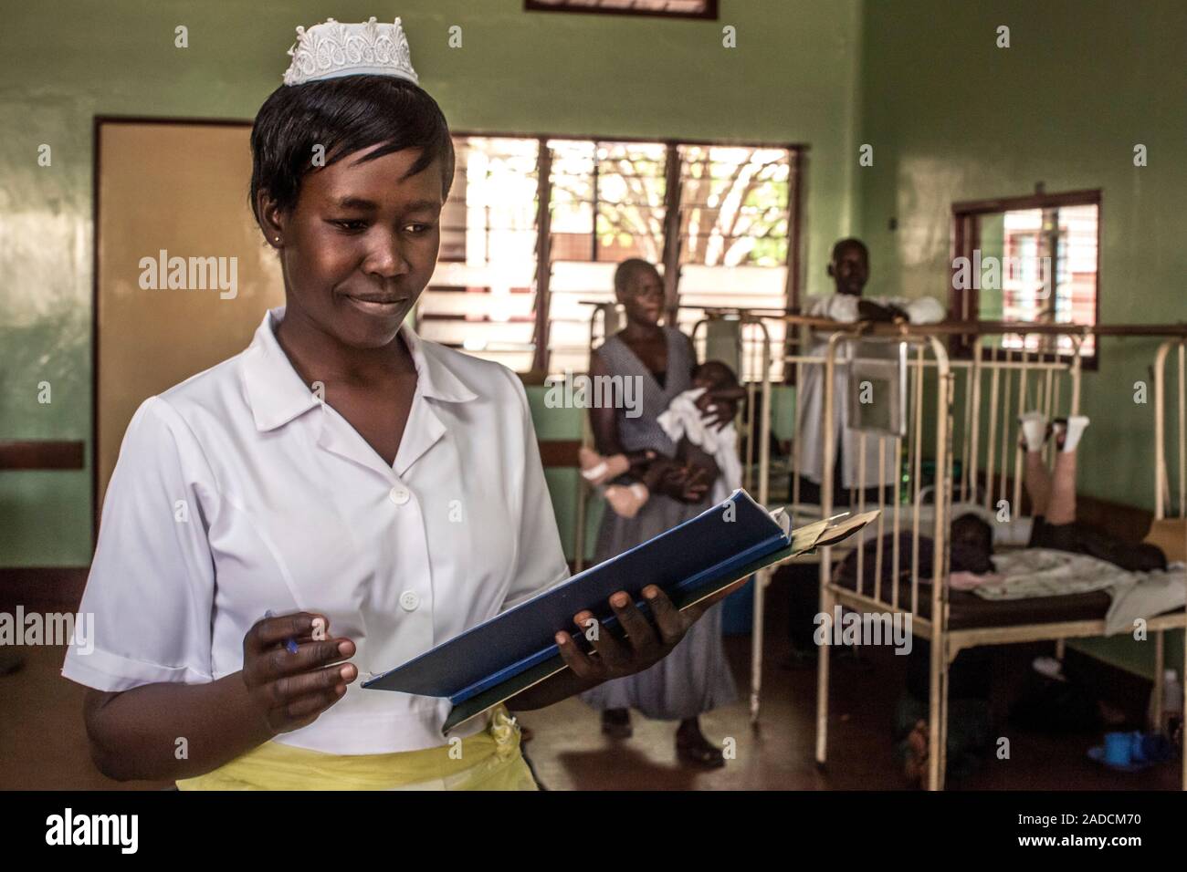 Hospital ward rounds. Nurse writing notes on child patients in a ...