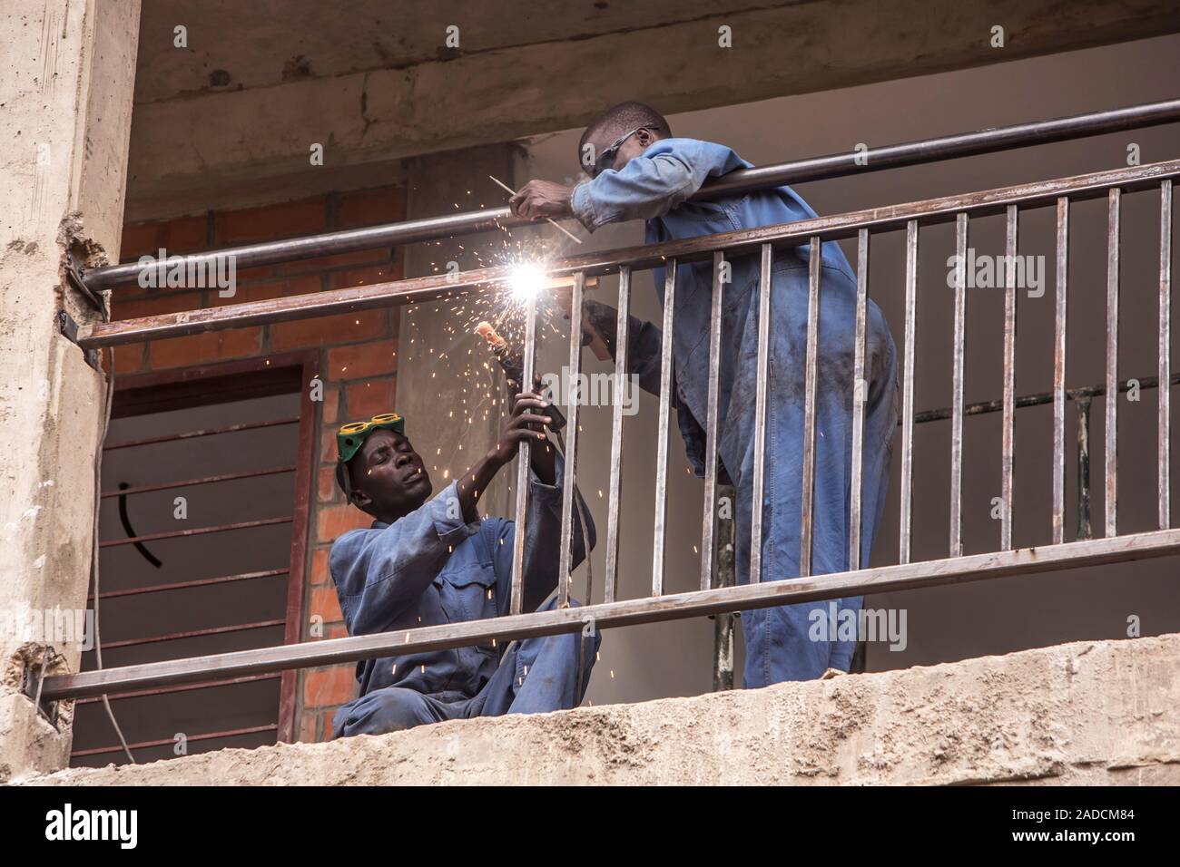 Construction workers welding railings on a building site. Photographed ...