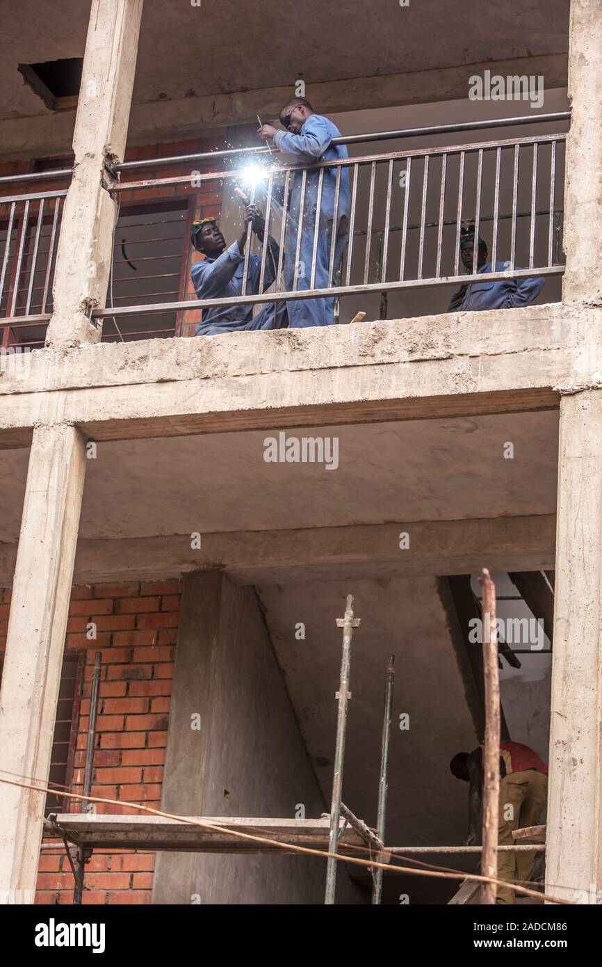 Construction workers welding railings on a building site. Photographed ...