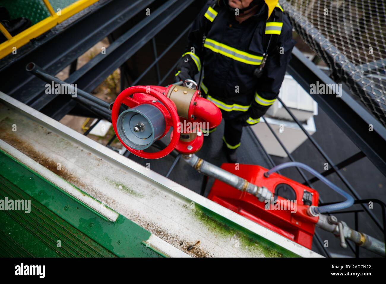 Details with the hands of a firefighter holding a fire suppression ...