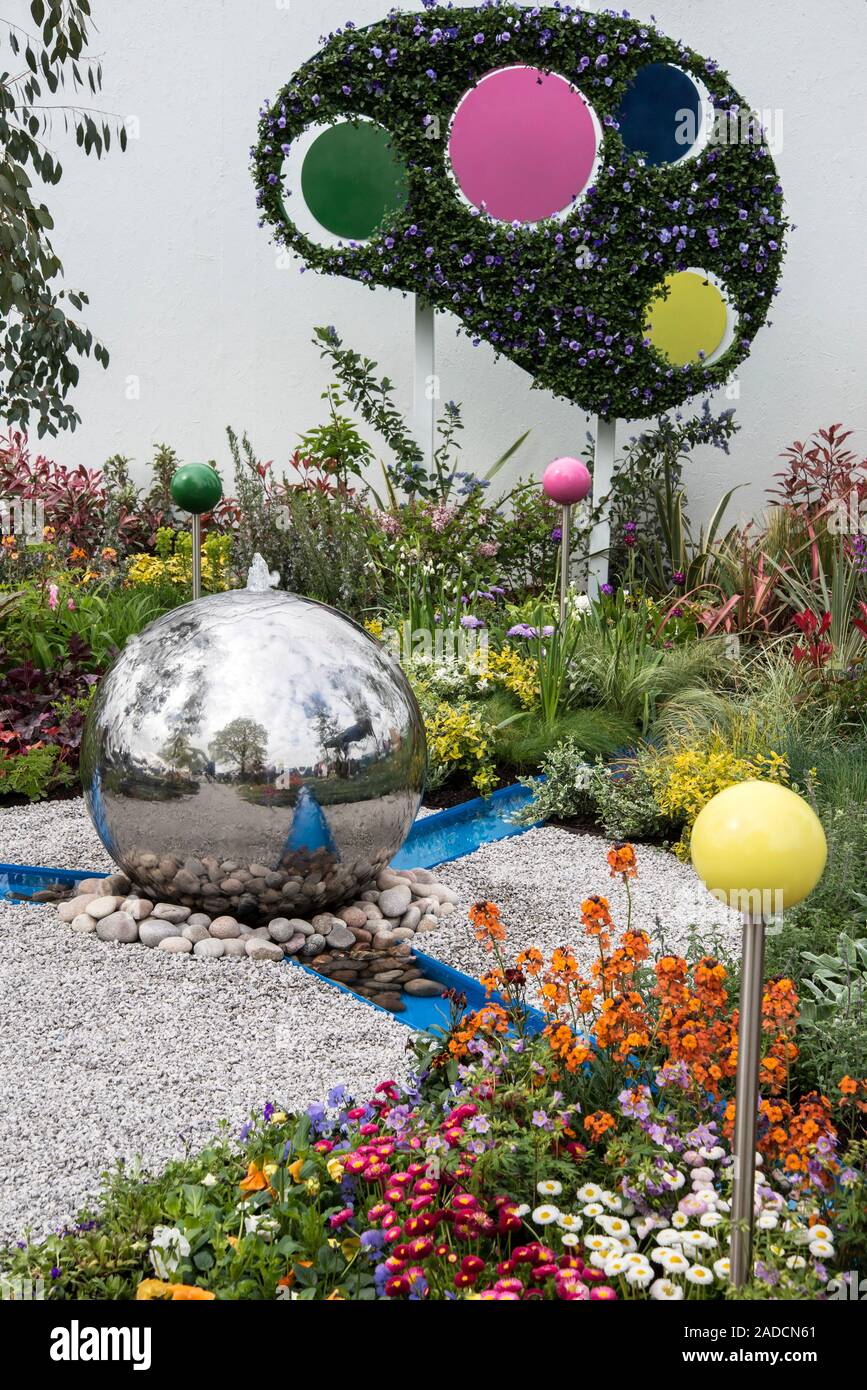 Contemporary show garden with spherical water feature, rills and ...
