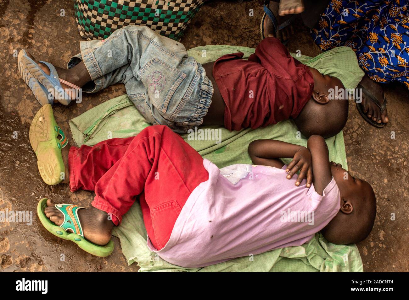 Children waiting outside a hospital. Two young children lying on the ...