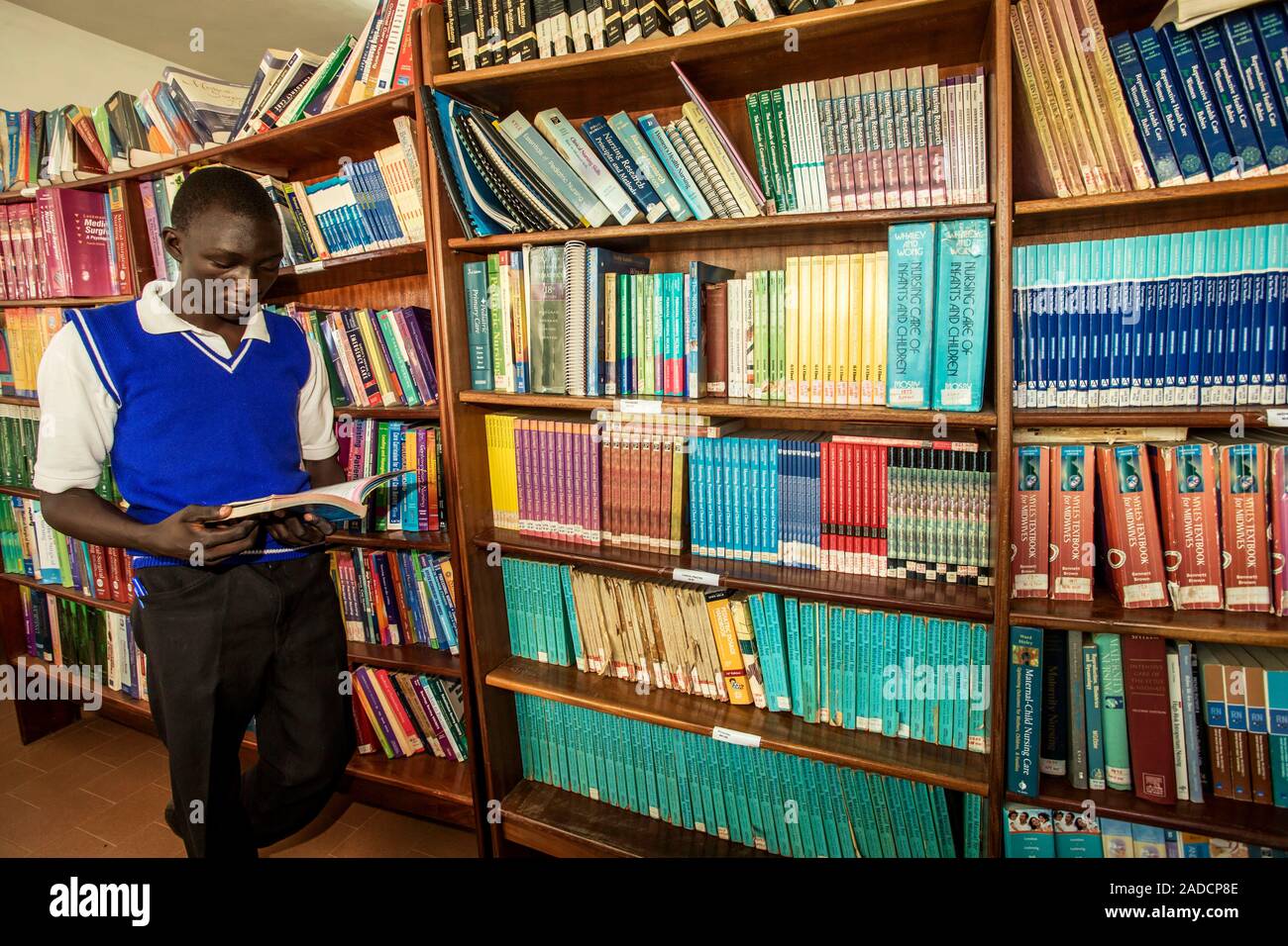 Student in a medical library. Schoolboy reading a book in a medical ...