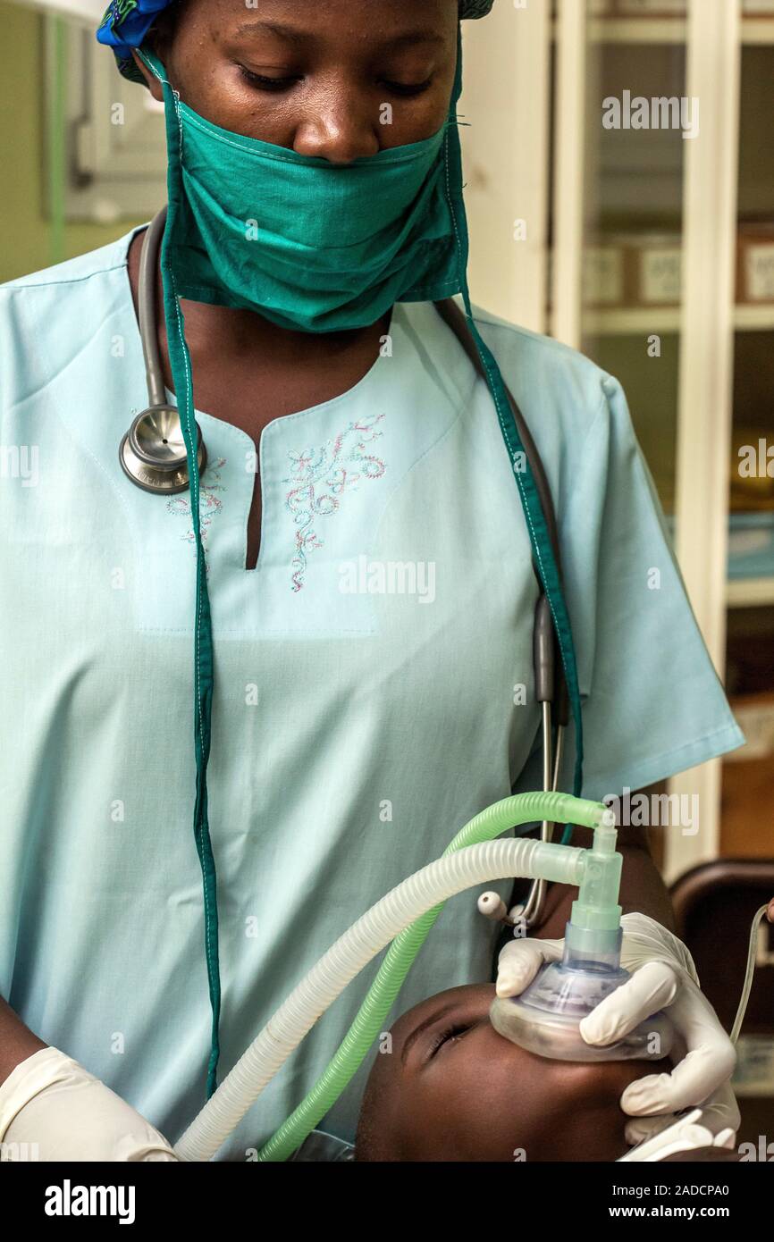 Anaesthetist monitoring a patient during surgery, ensuring the mask ...